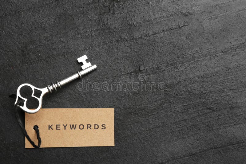 Vintage Key and Tag with Word KEYWORDS on Black Table, Top View. Space ...