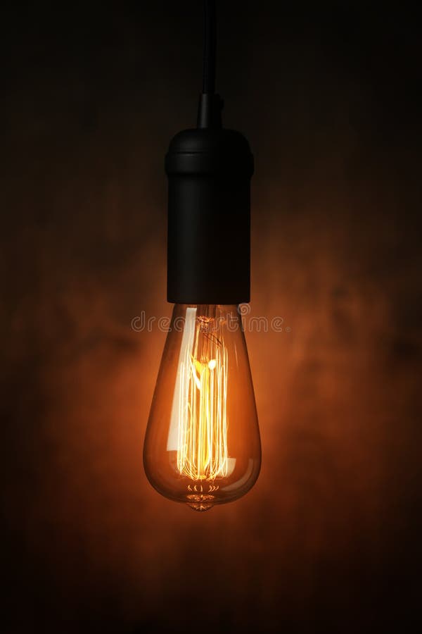 Vintage Old Light Bulb Glowing on Rough Dark Background Surrounded by ...