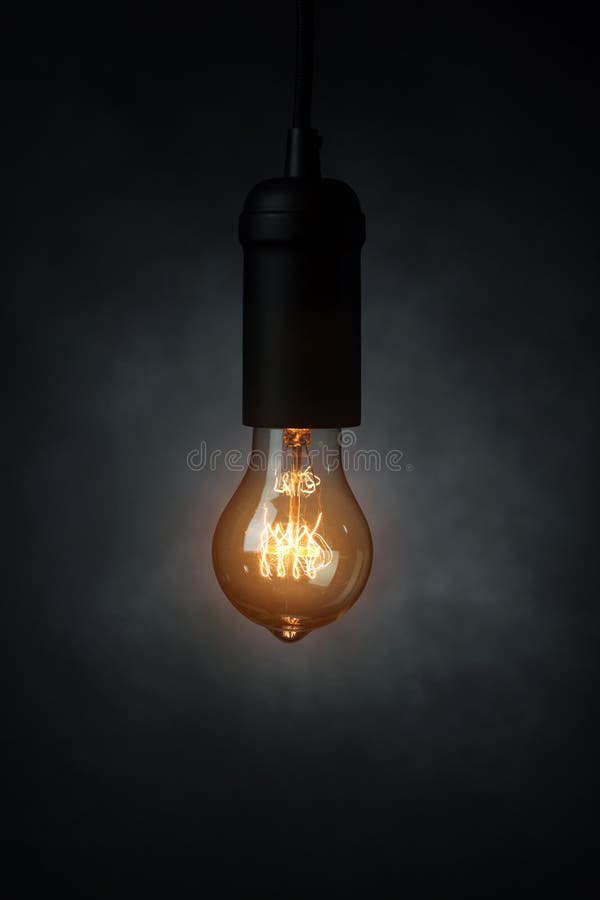 Vintage Old Light Bulb Glowing on Rough Dark Background Surrounded by ...
