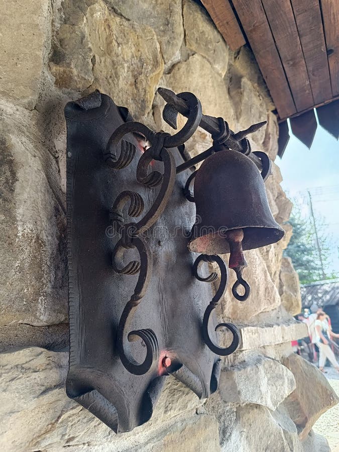 A Vintage Wrought Iron Bell with Intricate Scrollwork Mounted on a ...