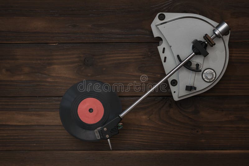 A Vinyl Record Player and a Red Disc on a Wooden Table. Stock Image ...