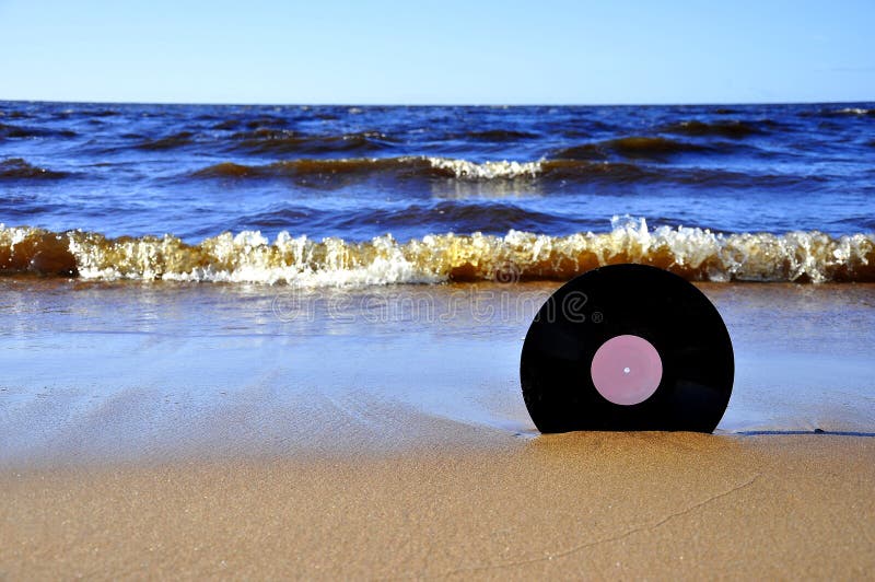 Vinyl Record Disk on the Sand Against the Background of the Sea Surf ...