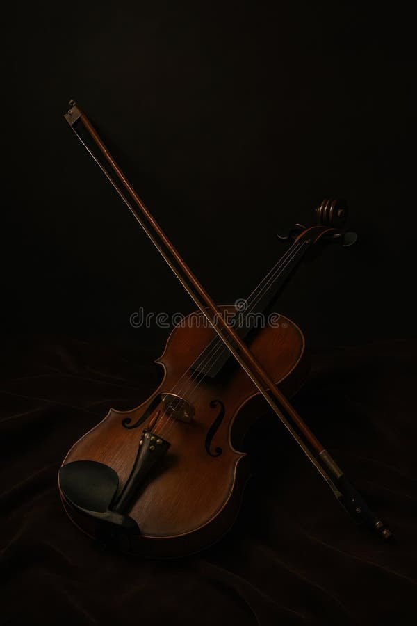 The Violin and Bow Lie on a Velvet Cloth in the Dark. Stock Image ...