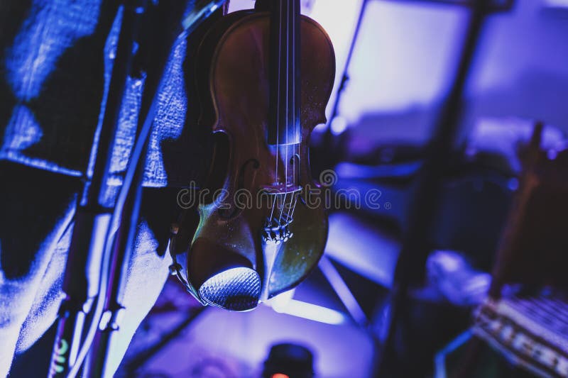 Violin Hanging on Microphone Stand in Blue Lighting on Stage Stock ...