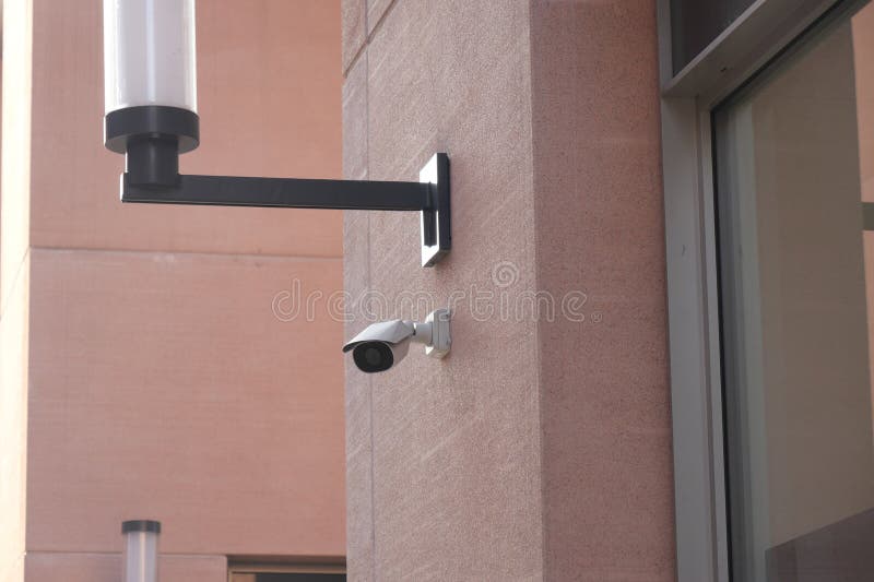 A Visibly Damaged Security Camera is Mounted on a Wall with Its Bracket ...