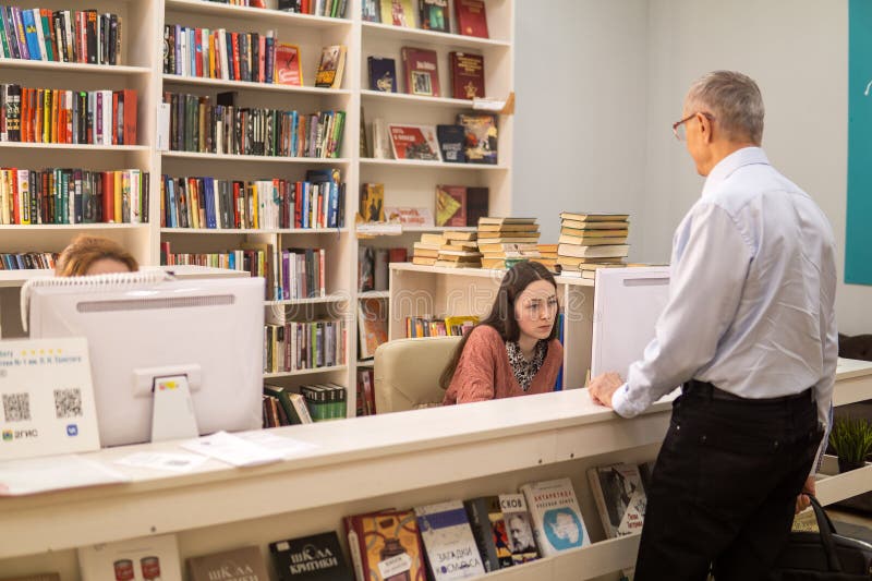 Visitor Communicates with a Librarian in a Library Editorial Stock ...