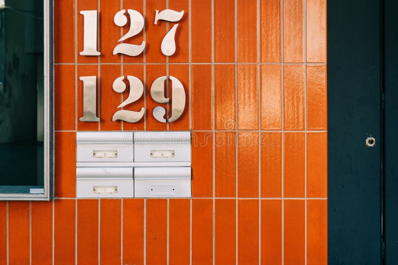Visual Contrast between White House Numbers and a Textured Orange ...