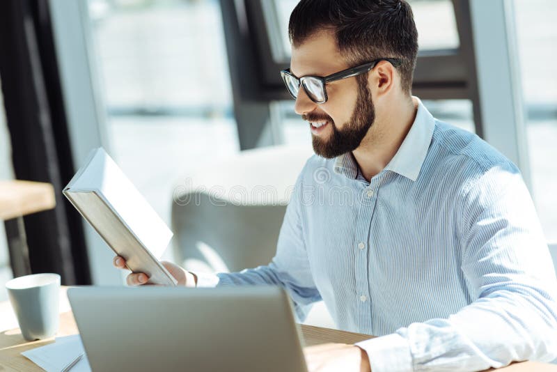 Pleasant Smiling Man Reading Notes in His Notebook Stock Image - Image ...