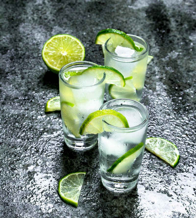Vodka with Pieces of Lime and Ice Cubes. Stock Image - Image of full ...