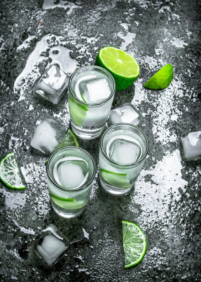 Vodka with Pieces of Lime and Ice Cubes. Stock Photo - Image of ...