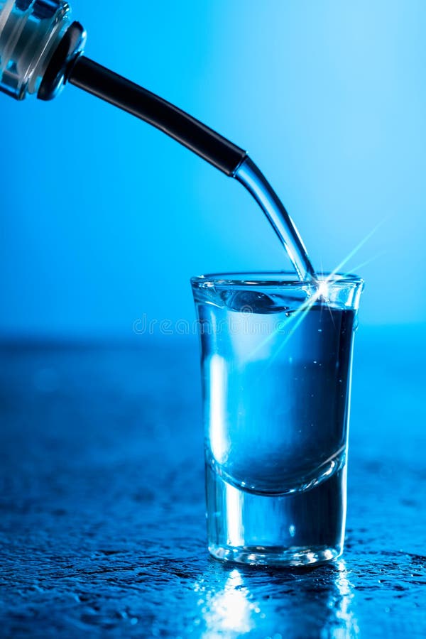 Vodka Poured into a Glass Lit with Blue Backlight Stock Image - Image ...
