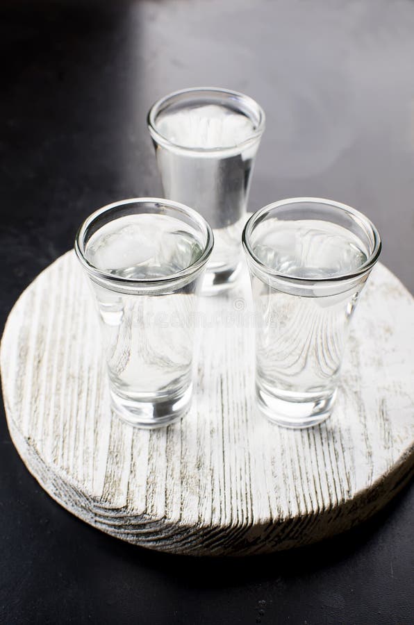 Vodka shots on black table stock image. Image of shot - 110607211