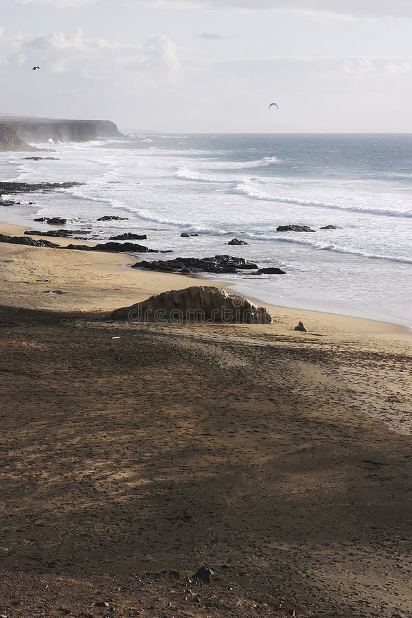 Volcanic Beach with Rock and Surf and Kitesurfer Stock Photo - Image of ...