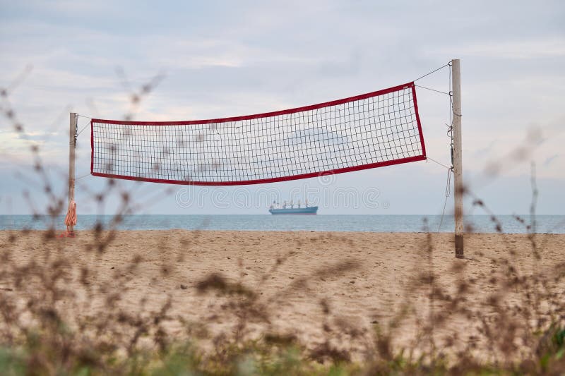 Volleyball Net on Empty Beach with Ship on a Horizon Stock Photo ...
