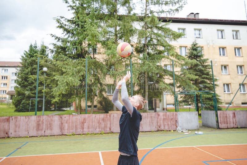 Volleyball Player Practicing Setting the Ball on a Hard Court, Focusing ...
