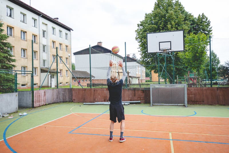 Volleyball Player Practicing Setting the Ball on a Hard Court, Focusing ...
