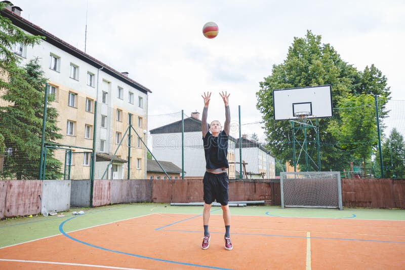 Volleyball Player Practicing Setting the Ball on a Hard Court, Focusing ...