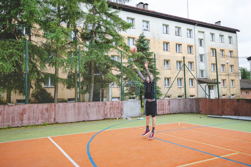 Volleyball Player Practicing Setting the Ball on a Hard Court, Focusing ...