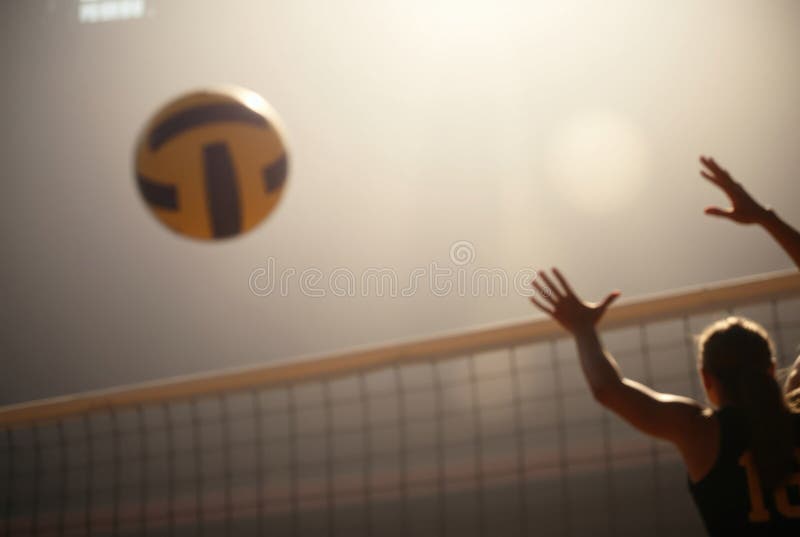 Volleyball Suspended in Mid-air Momentarily Above the Net during a Game ...
