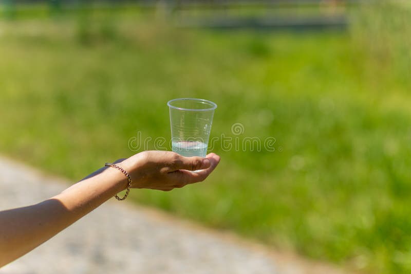 A Volunteer Hand Holds a Plastic Cup of Water for Runners Stock Photo ...