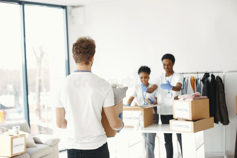 Volunteers Sort through Boxes with Help Stock Photo - Image of help ...
