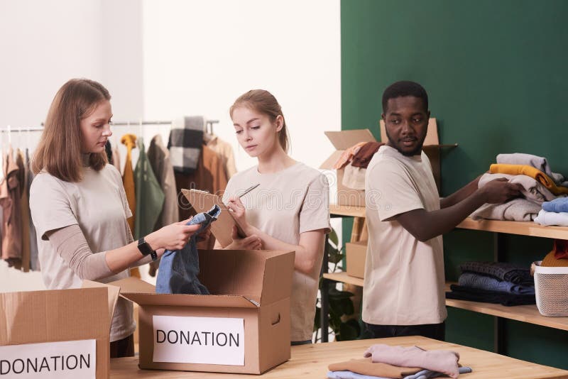 Volunteers Sorting Clothes stock photo. Image of lifestyles - 243909644
