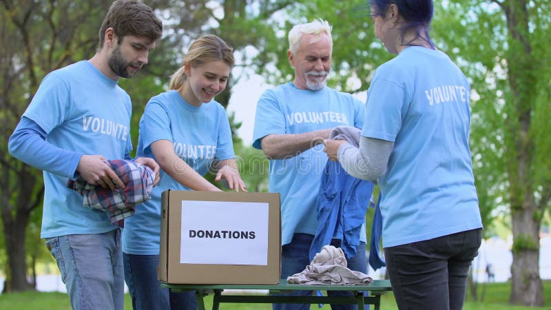 Volunteers Sorting Clothes Putting in Donation Box, Philanthropic ... Volunteers Sorting Clothes Putting in Donation Box, Philanthropic ...