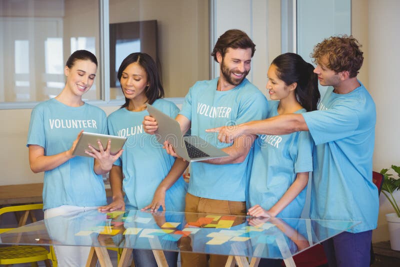 Volunteers using a laptop stock photo. Image of participate - 77689572