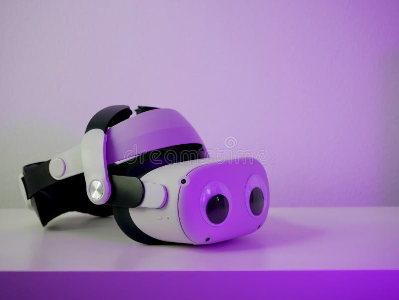 Vr Virtual Reality Glasses Helmet With Eye Stickers Lying On A White Table In Violet Neon Light
