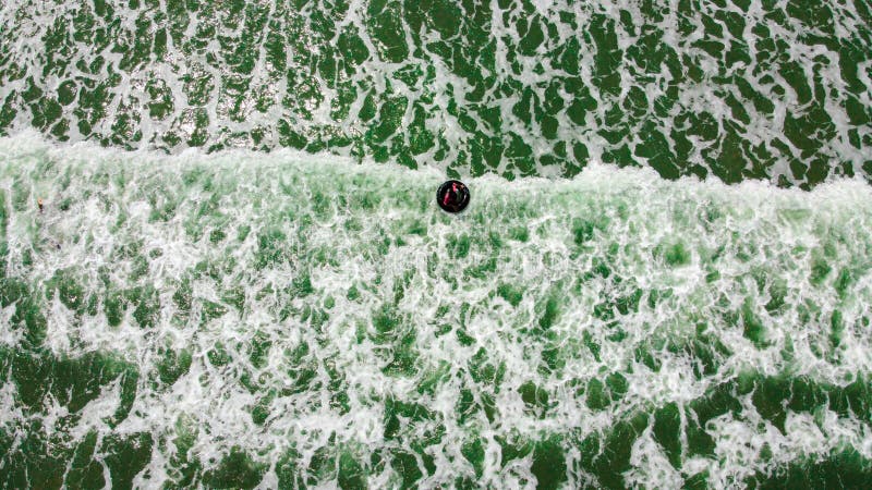 Wading Big Waves with a Life Tube Stock Photo - Image of waves, flower ...