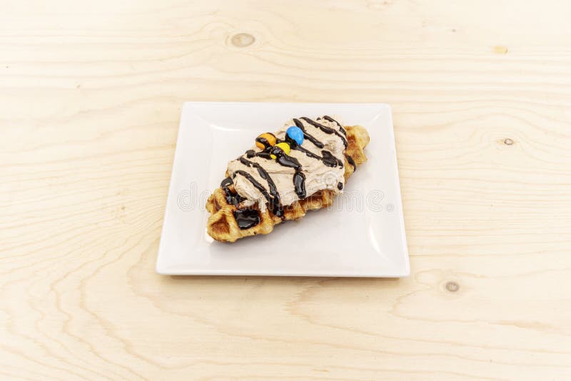 A Waffle-style Confection with Chocolate Syrup, Cream and Small Colored ...