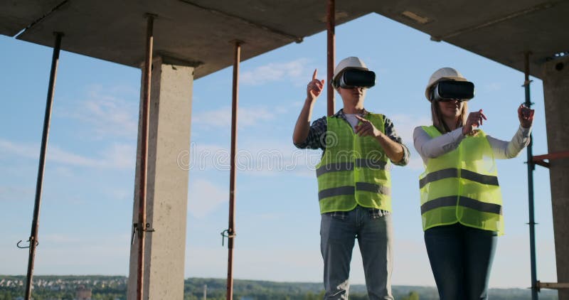 Waist Up Portrait of Two Modern Construction Workers Using VR Gear To ...