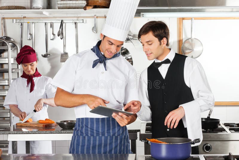 Waiter and Chef Using Digital Tablet in Kitchen Stock Photo - Image of ...