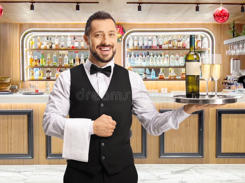 Waiter in Front of a Bar Holding a Bottle of Wine Stock Image - Image ...