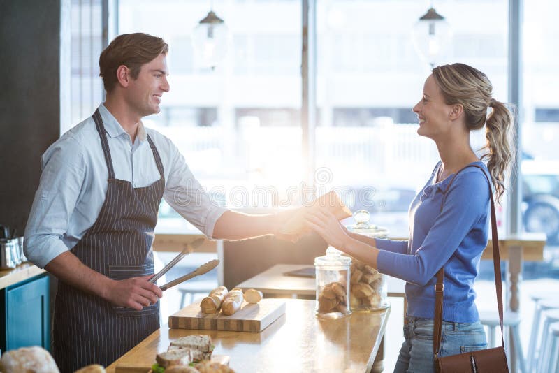Waiter Giving Parcel To Customer at Counter Stock Photo - Image of ...