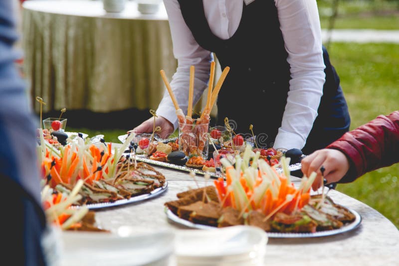 The Waiter Puts Snacks on a Buffet Stock Photo - Image of tomato, feast ...