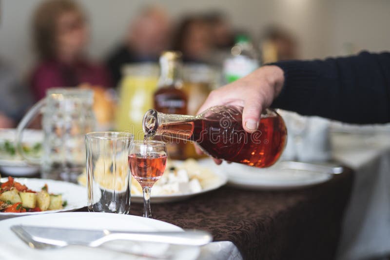 A Waiter in a Restaurant Pours Alcohol into a Glass at the Table Stock ...