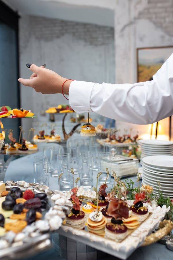 A Waiter Serves a Buffet Table at the Event Stock Photo - Image of ...