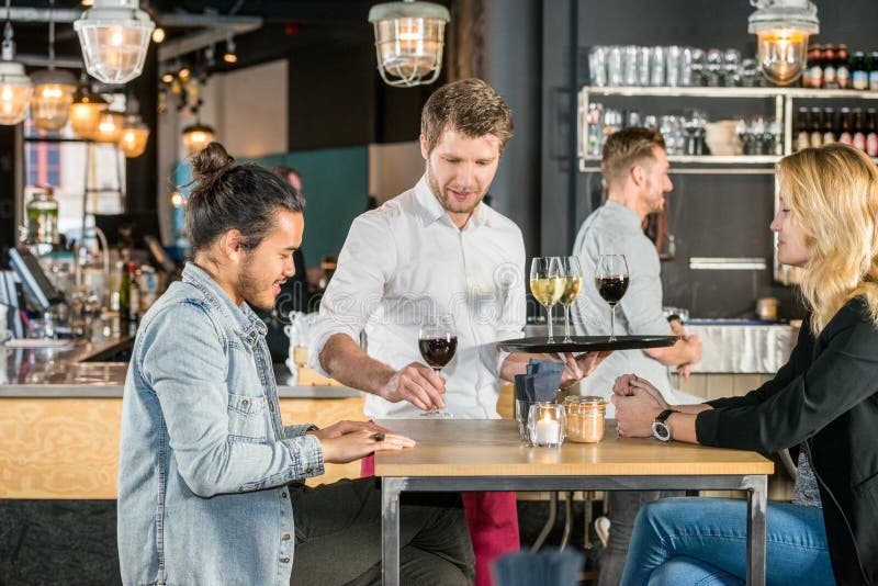 Waiter Serving Food To Customers in Cafe Stock Photo - Image of serving ...