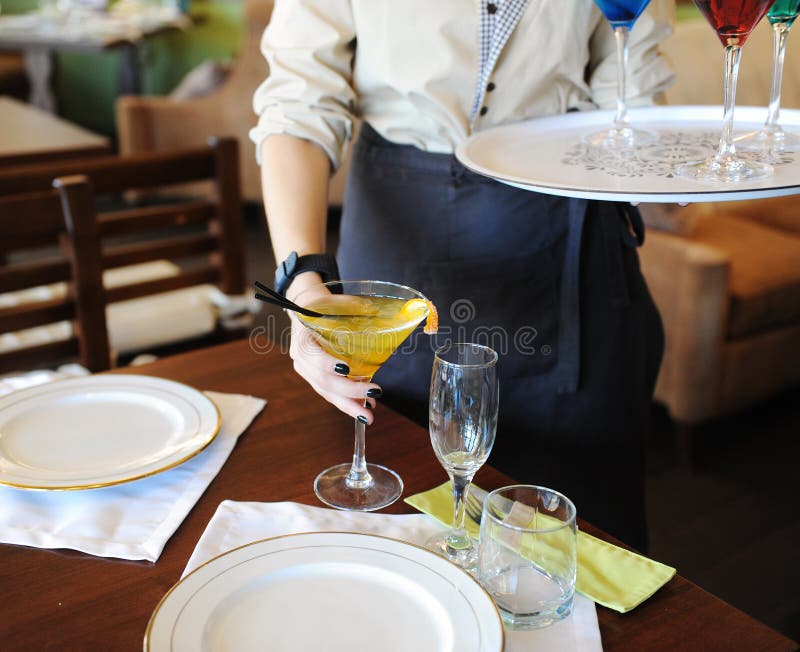 The Waiter Takes on the Table Yellow Cocktail. White Plates on the ...