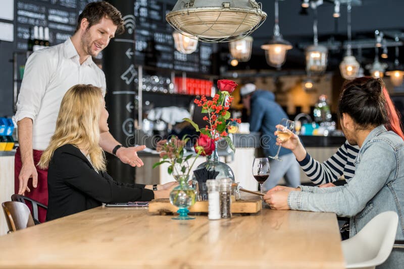 Waiter Taking Order from Customers in Cafe Stock Photo - Image of ...