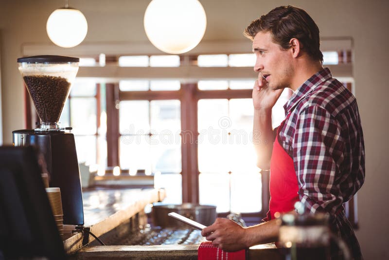Waiter Talking on Mobile Phone while Using Digital Tablet Stock Photo ...