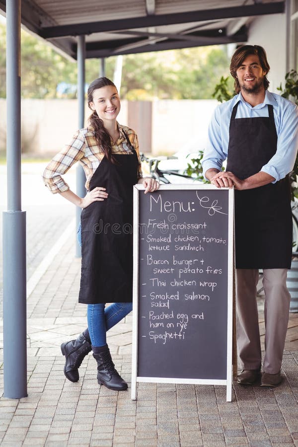 Waiter and Waitress Standing with Menu Board Outside the Cafe Stock ...