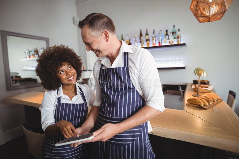 Waiter and Waitress Using Digital Tablet at Counter Stock Image - Image ...