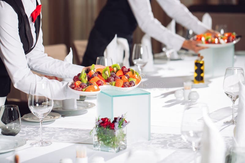 Waiters Serving Table in the Restaurant Preparing To Receive Guests ...