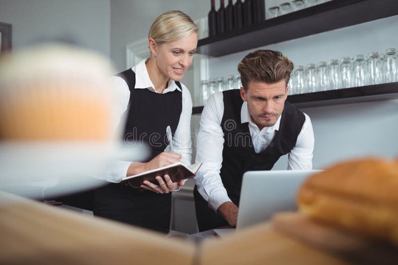 Waiters Using Laptop at Counter Stock Image - Image of coat, counter ...