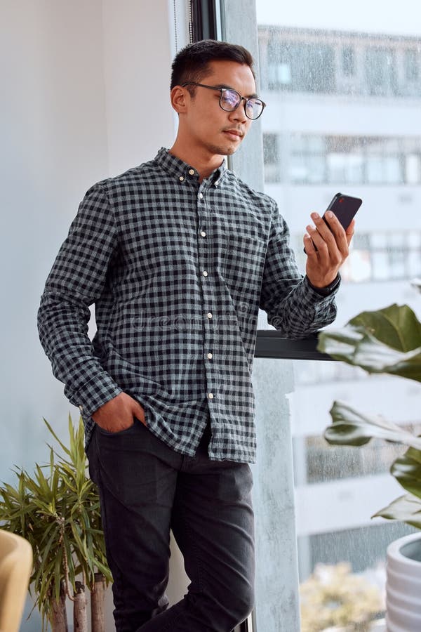 Waiting for an Email. a Young Businessman Using a Phone in an Office ...