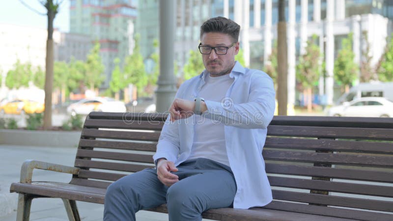 Waiting Man Checking Time while Sitting Outdoor on Bench Stock Image ...