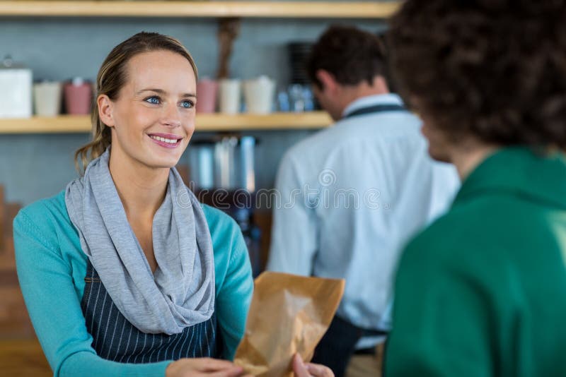 Waitress Giving Parcel To Customer at Counter Stock Photo - Image of ...