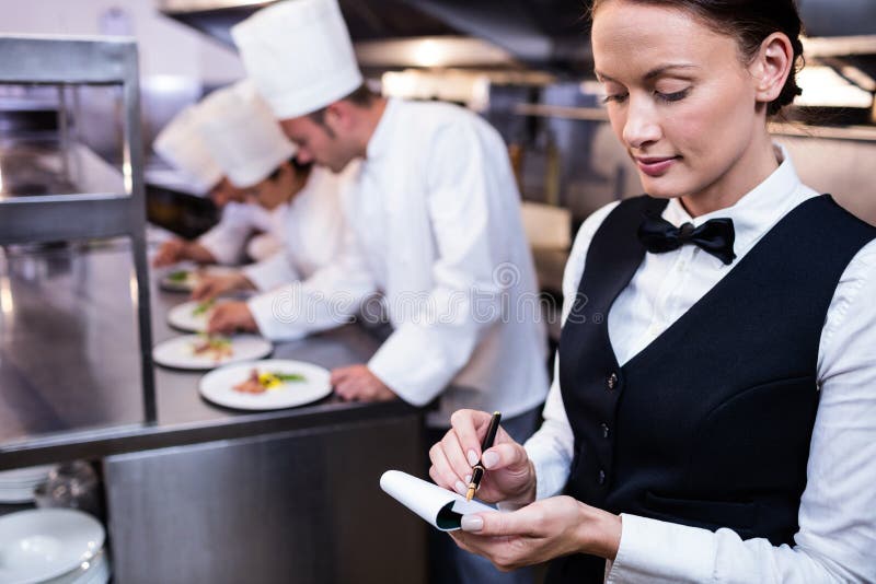 Waitress with Note Pad in Commercial Kitchen Stock Photo - Image of ...